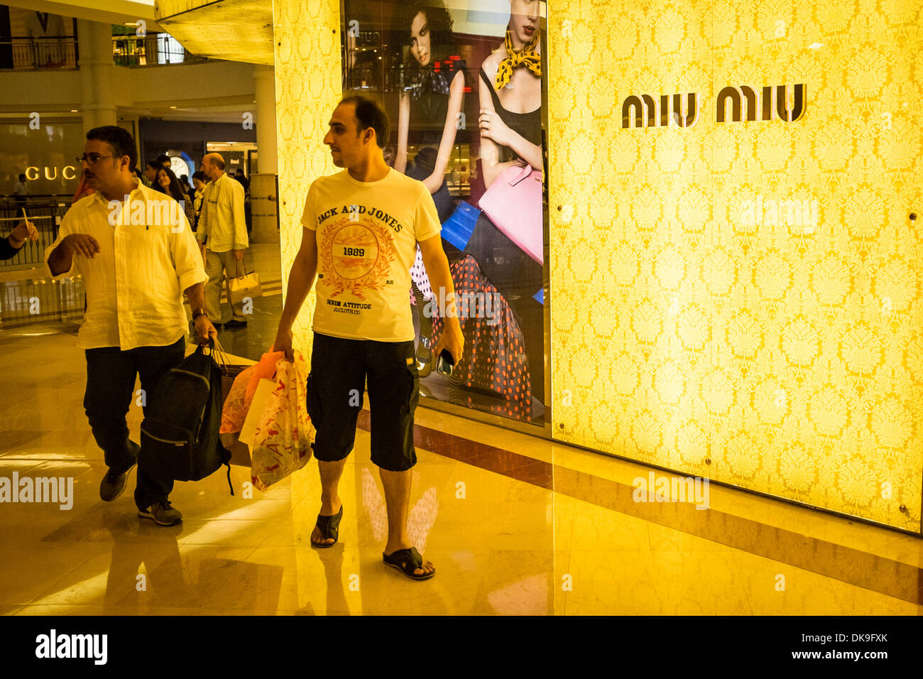 Men walk by the Miu Miu shop in the Suria KLCC shopping mall in Kuala ...