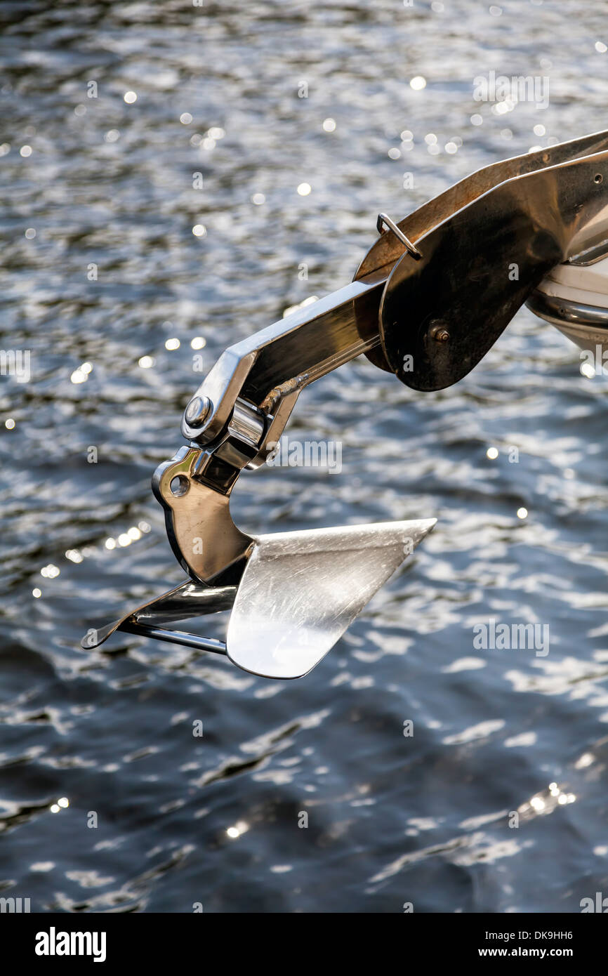 Stainless steel boat anchor stowed in a bracket at the bow of a yacht ...