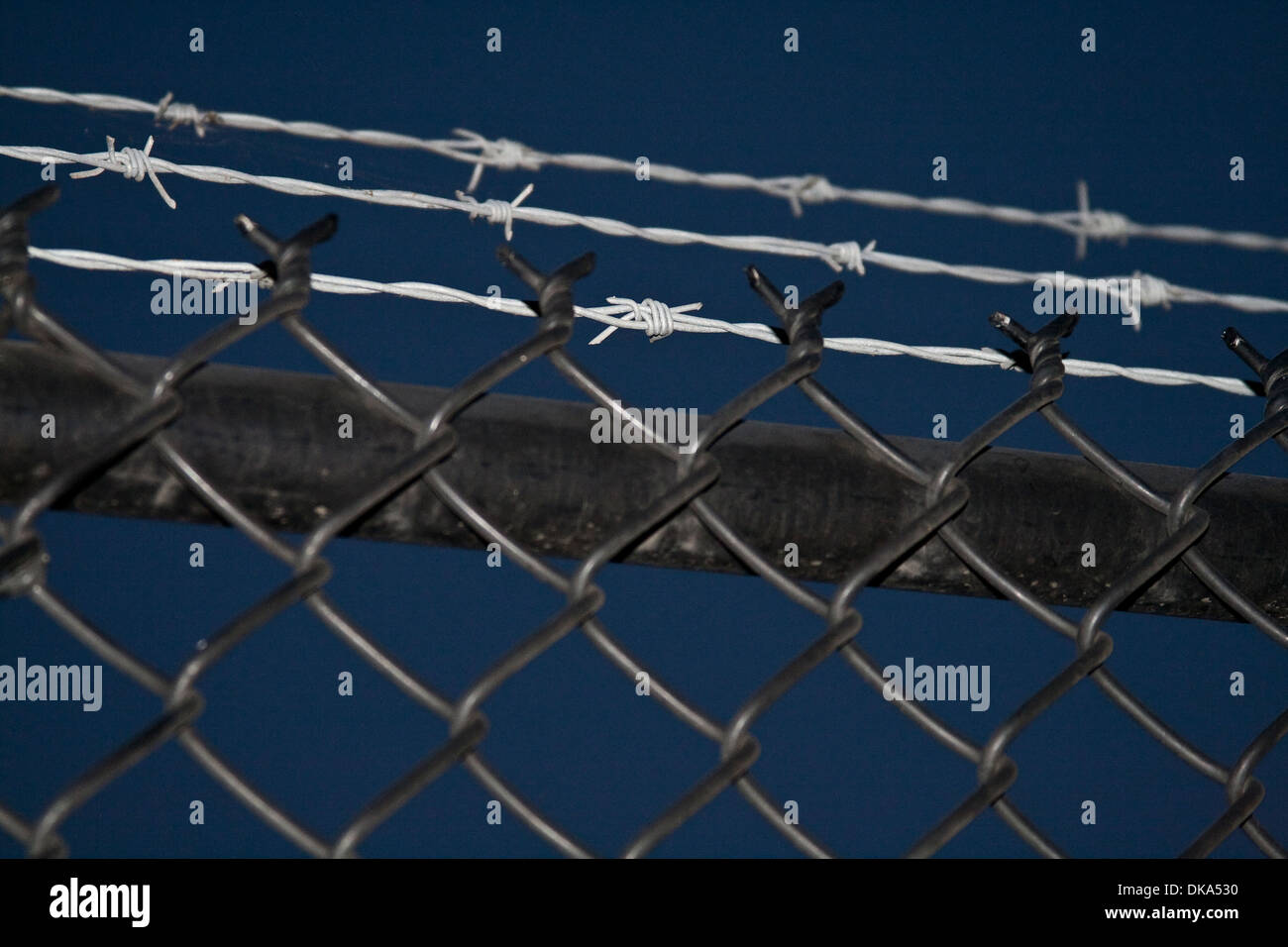 Chain link fence with barbed razor wire in Los Angeles Stock Photo - Alamy