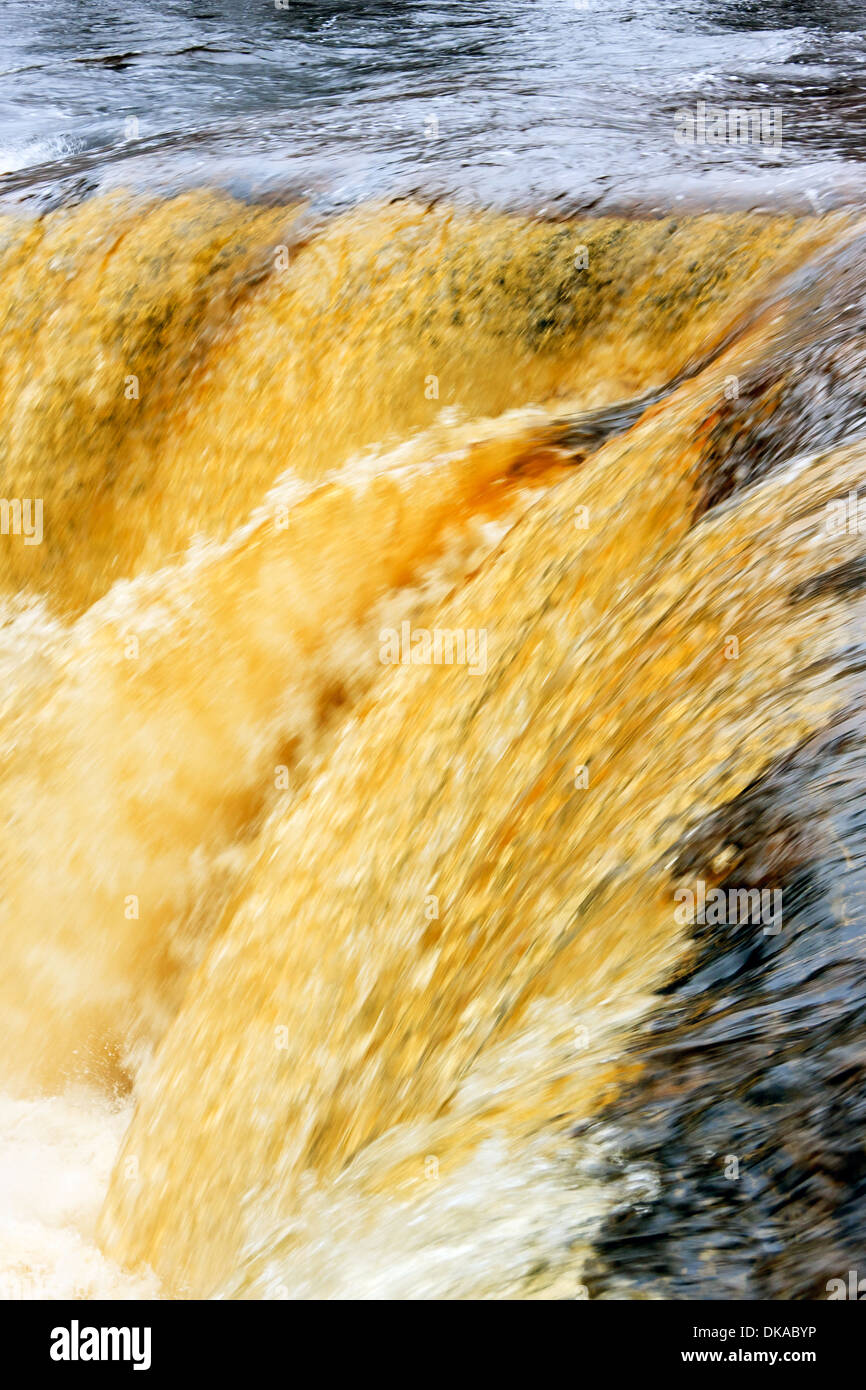 Smooth falling water of a yellow natural waterfall Stock Photo - Alamy