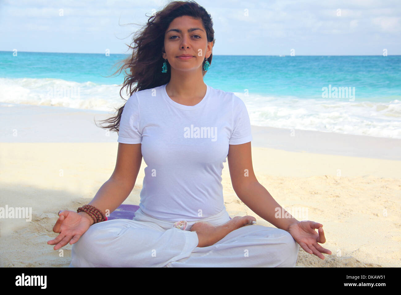 Female doing lotus position on beach, Paradise Island, Nassau, Bahamas ...