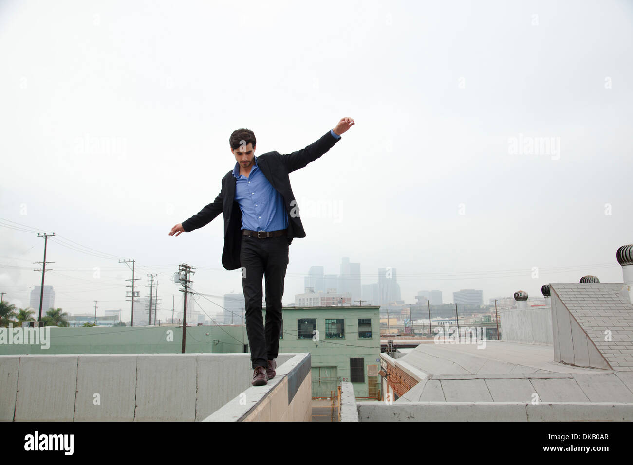 Young man walking wall on city rooftop Stock Photo - Alamy