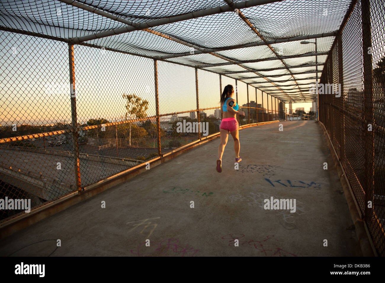 Female jogger running on walkway Stock Photo - Alamy