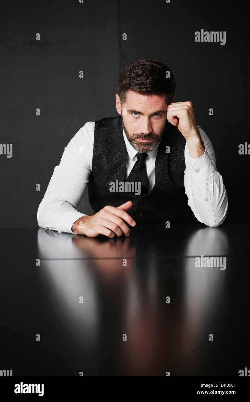 Businessman wearing waistcoat and shirt leaning on elbow Stock Photo ...