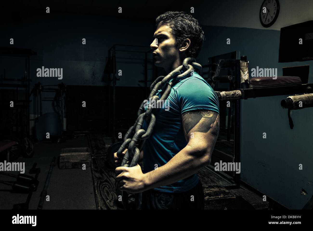 Weightlifter in dark gym, chain around his neck Stock Photo - Alamy