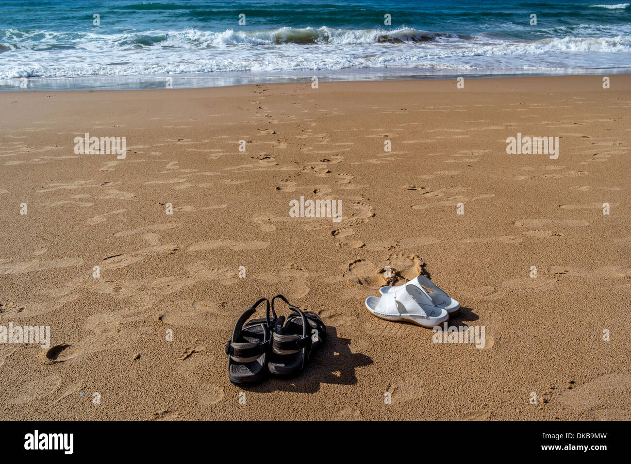 Footprints and sandals left on the beach Stock Photo - Alamy