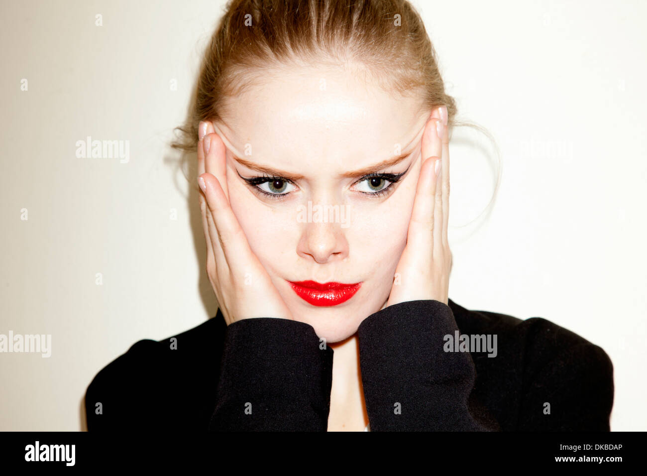 Head shot of young woman pushing cheeks up Stock Photo - Alamy