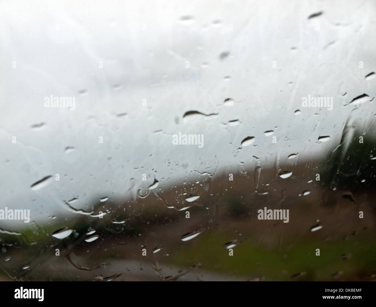 Water drops on the glass front of the car on a rainy day in autumn ...