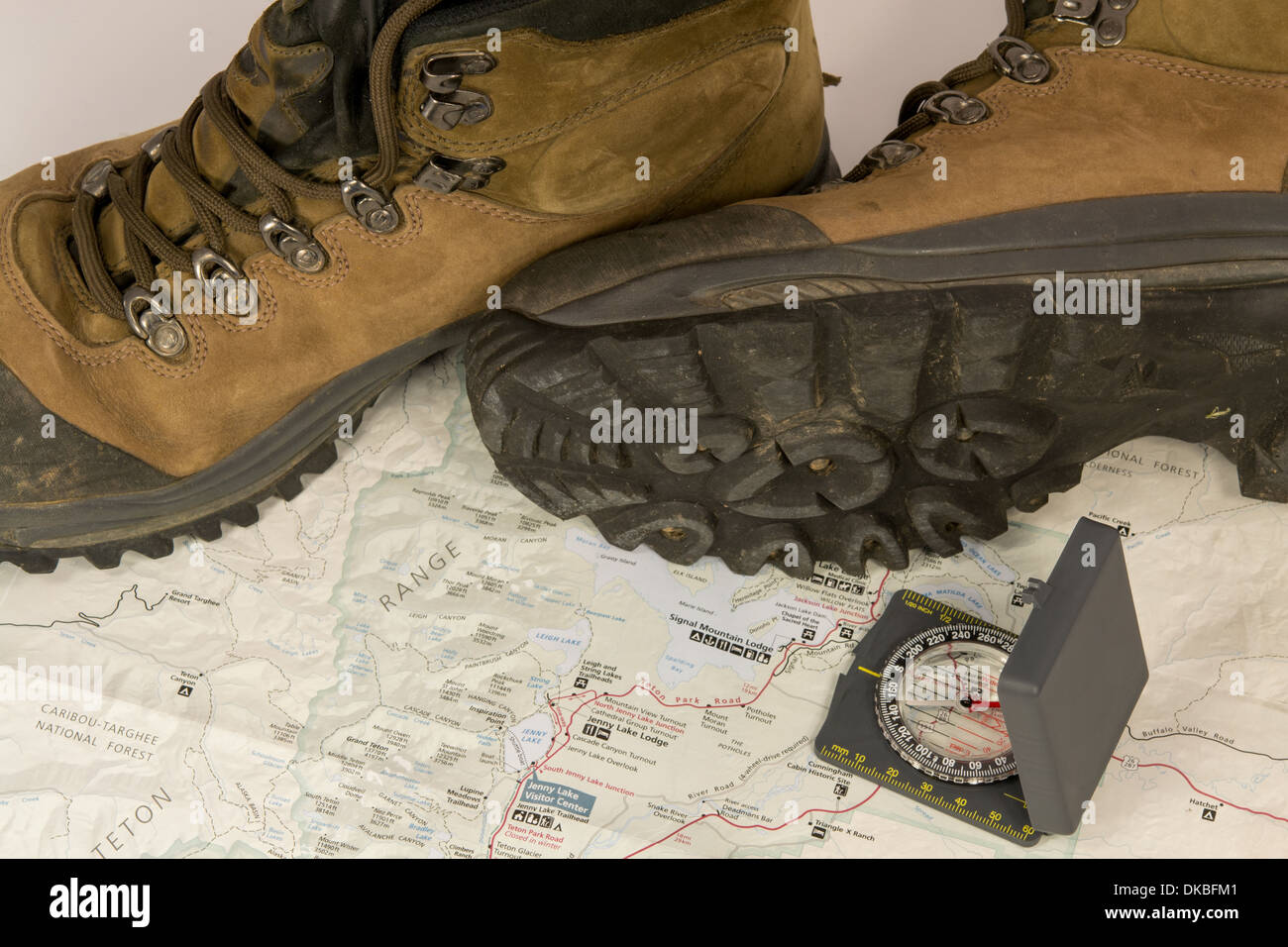 A pair of worn leather men's hiking boots set on a trail map with ...