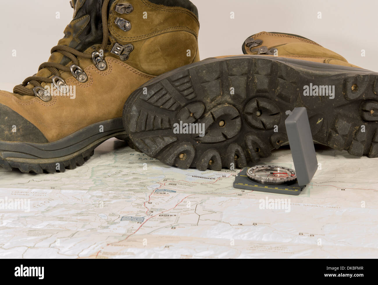 A pair of worn leather men's hiking boots set on a trail map with ...