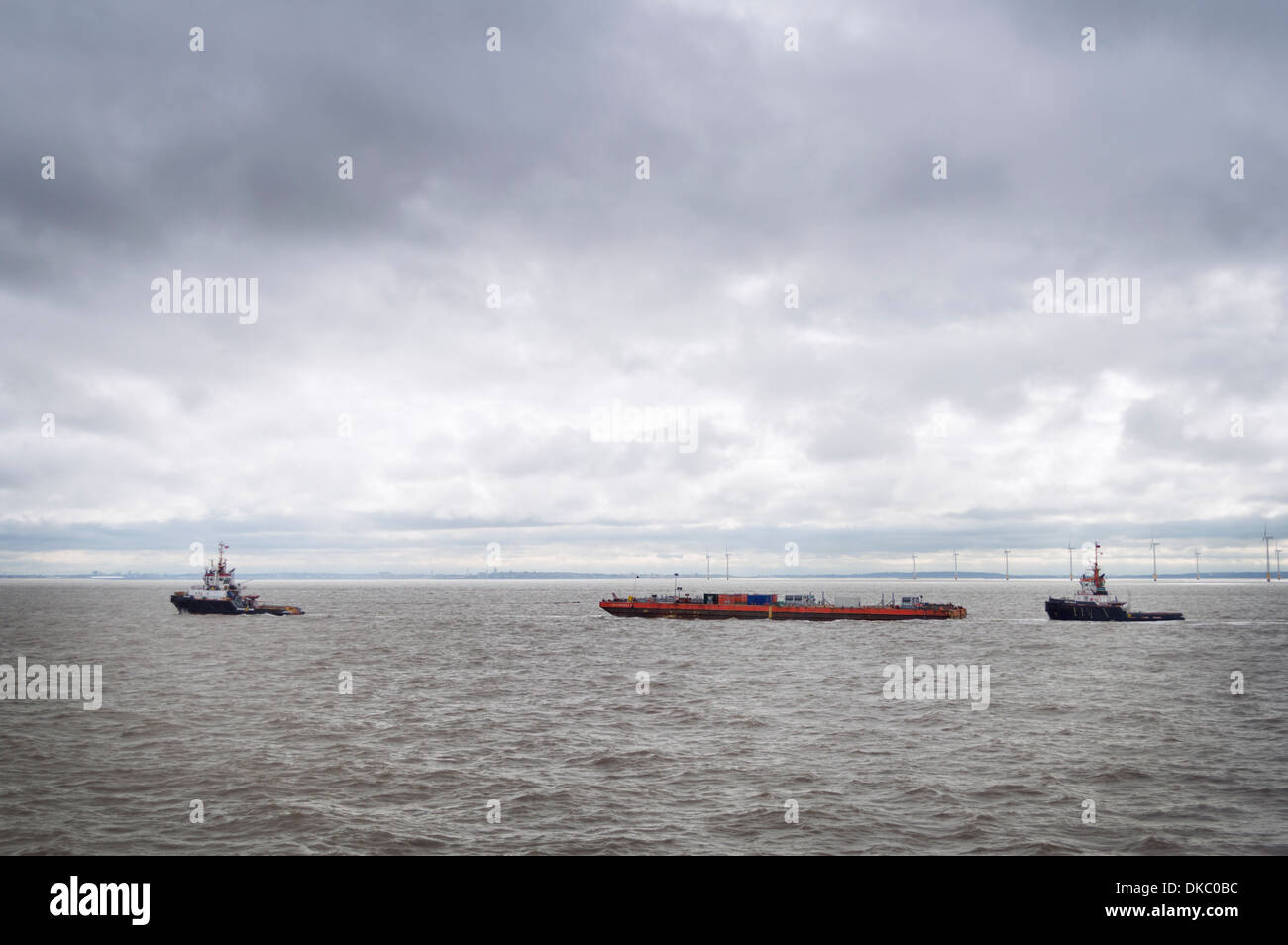 Mersey Estuary, UK - tugs escorting cargo vessel into port Stock Photo ...