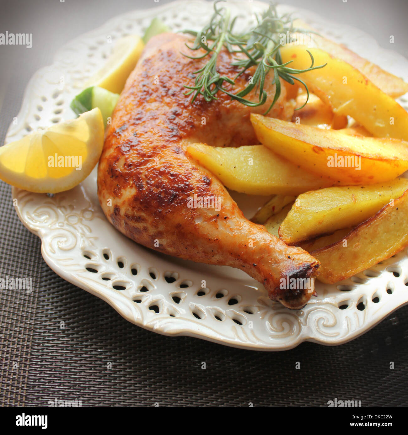 roasted chicken leg with fries potato and lemon Stock Photo - Alamy