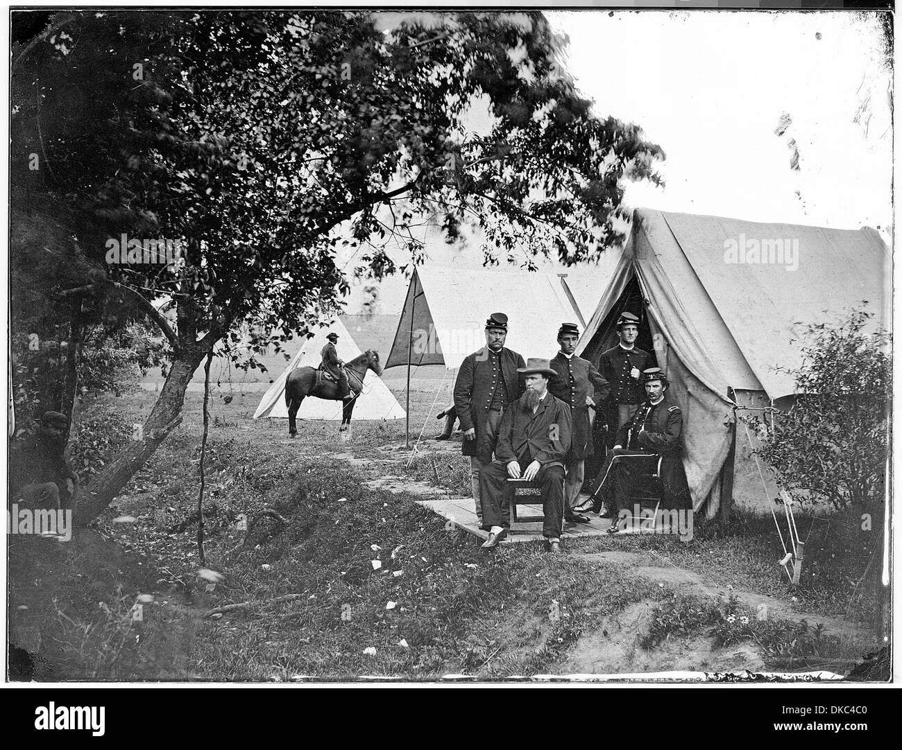A group of military officers is shown at a camp, likely during a ...