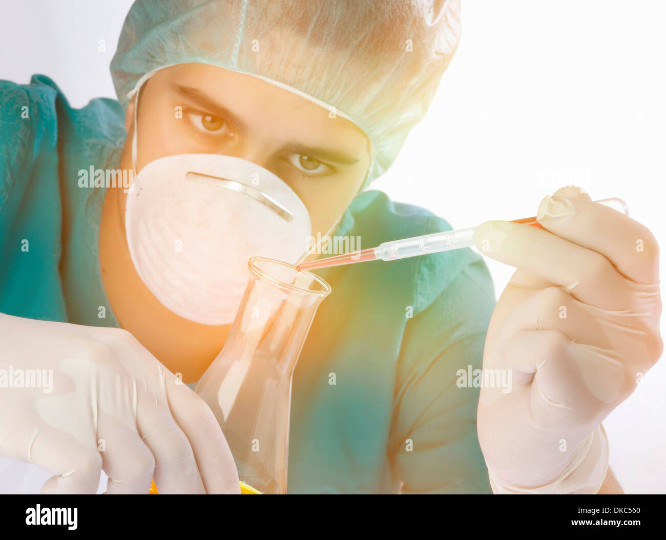 Scientist dropping liquid into flask Stock Photo - Alamy