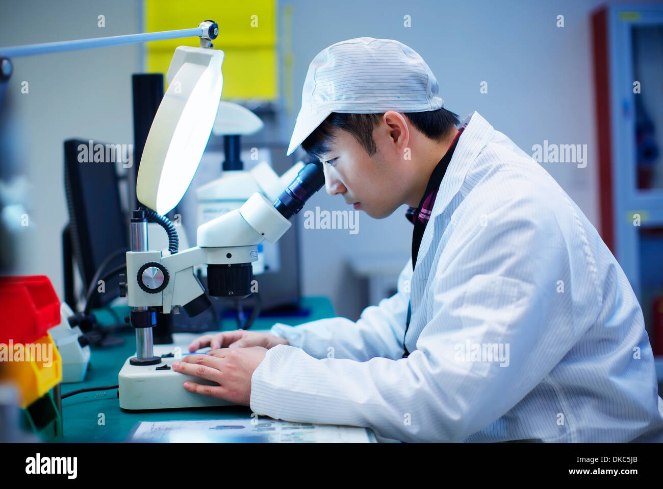 Workers at small parts manufacturing factory in China looking through ...