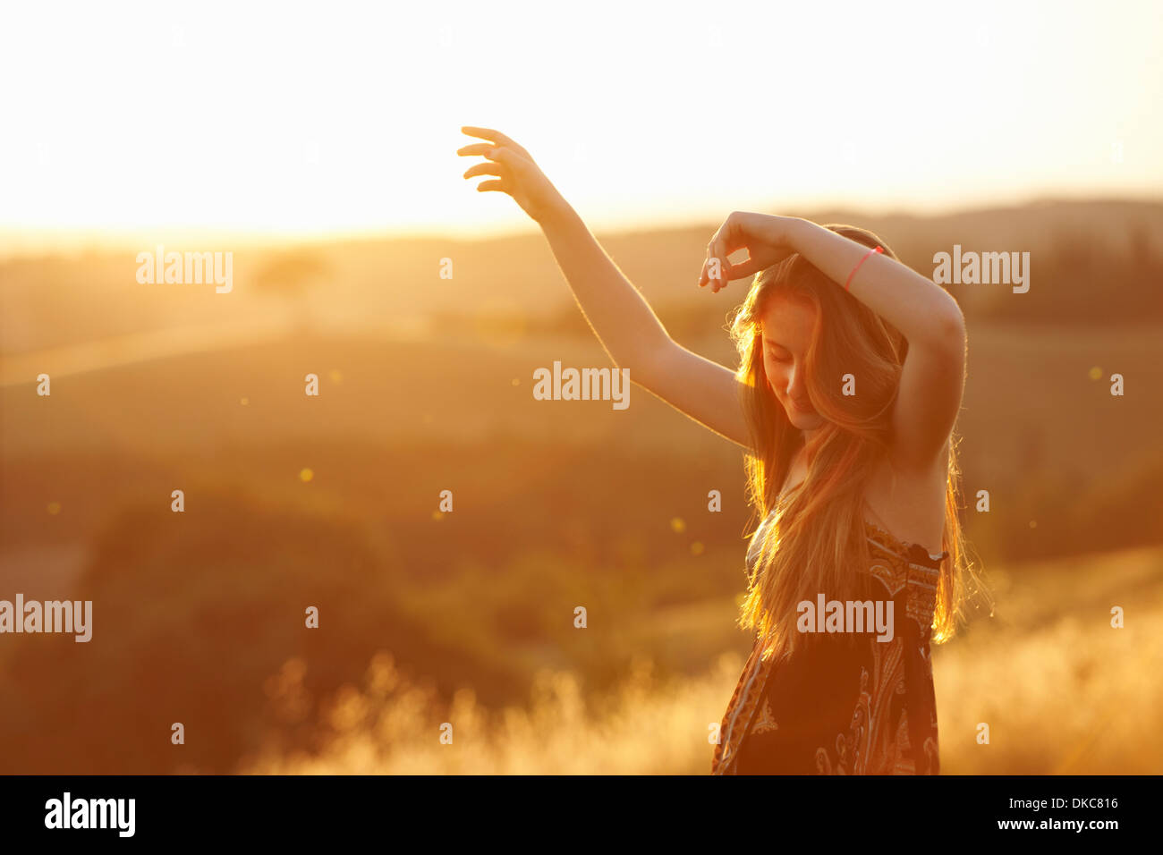 Teenager dancing in field at dusk Stock Photo - Alamy