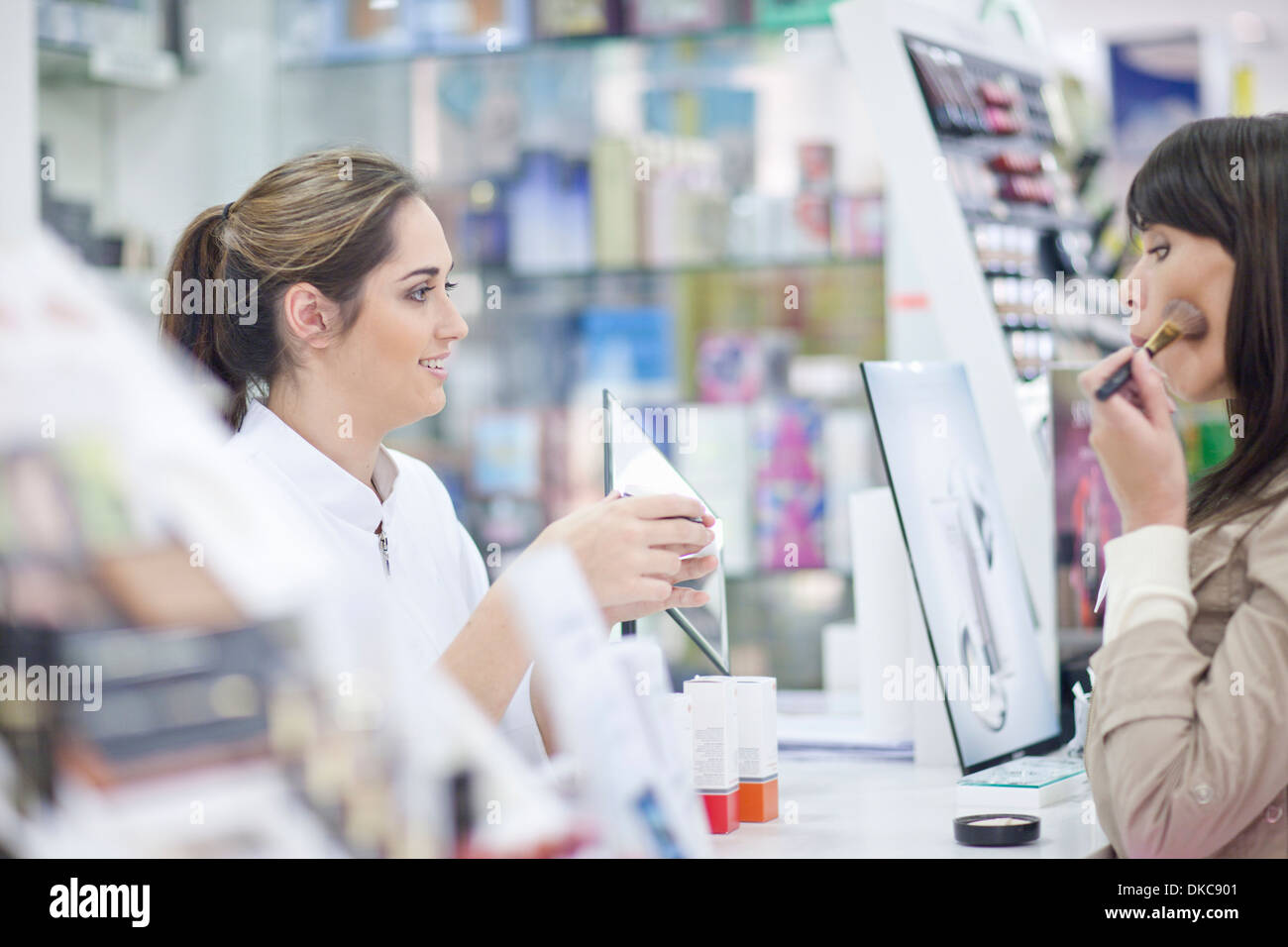 Shop assistant doing make up demonstration Stock Photo - Alamy