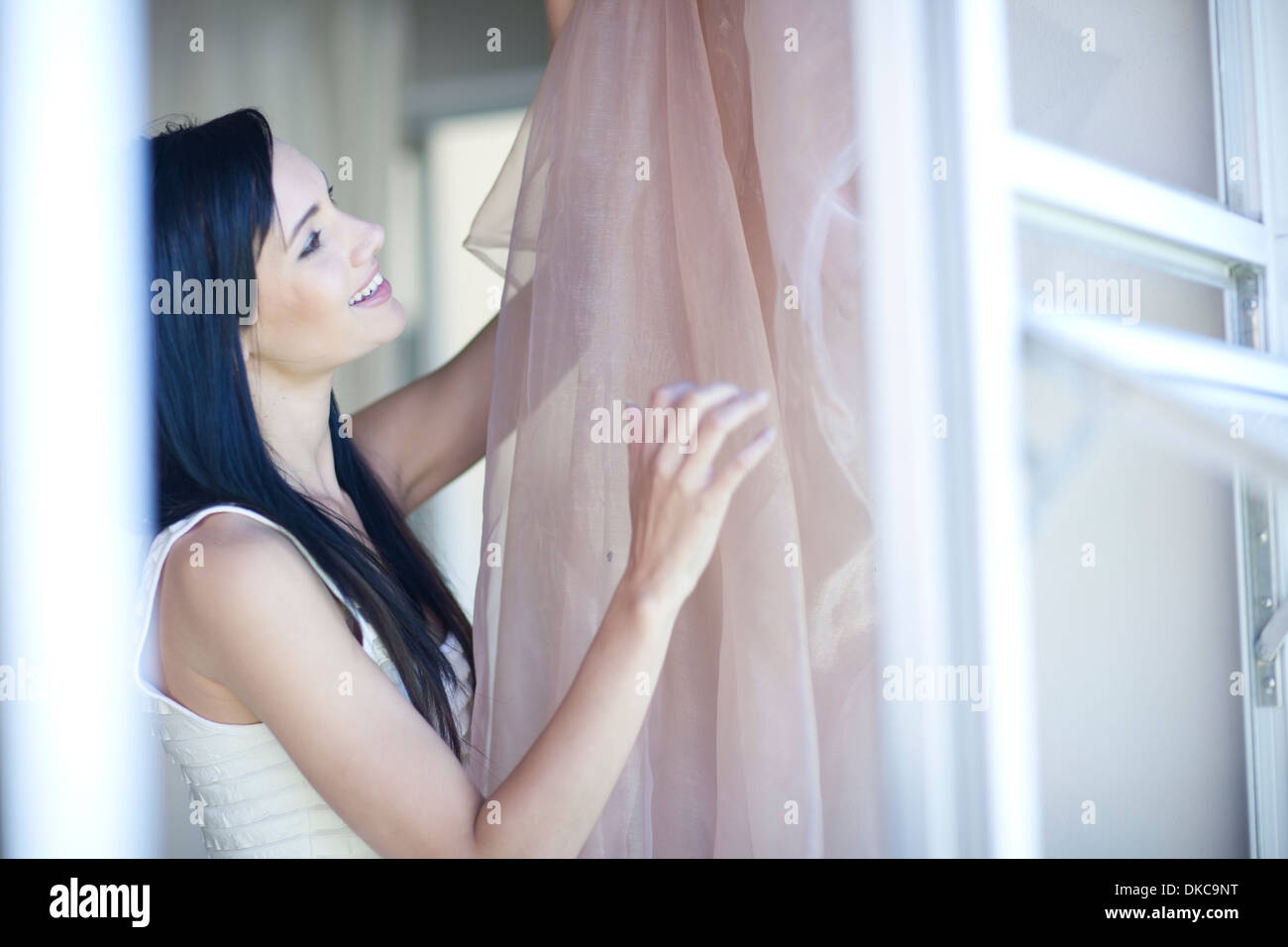 Interior designer holding up netting to window Stock Photo - Alamy