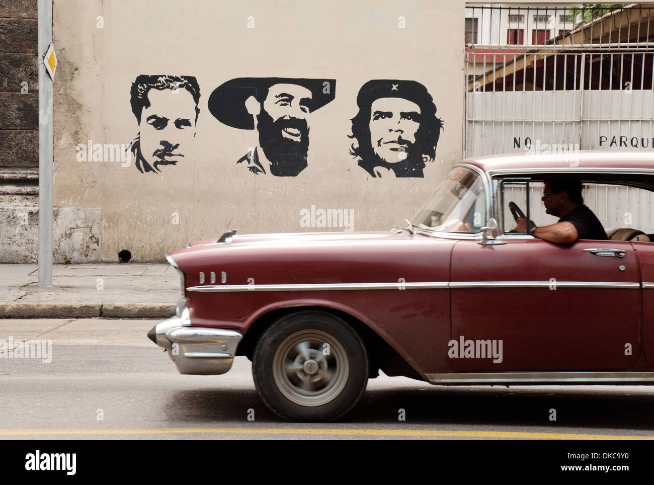 Old American car driving past images of Cuban Revolution heroes ...