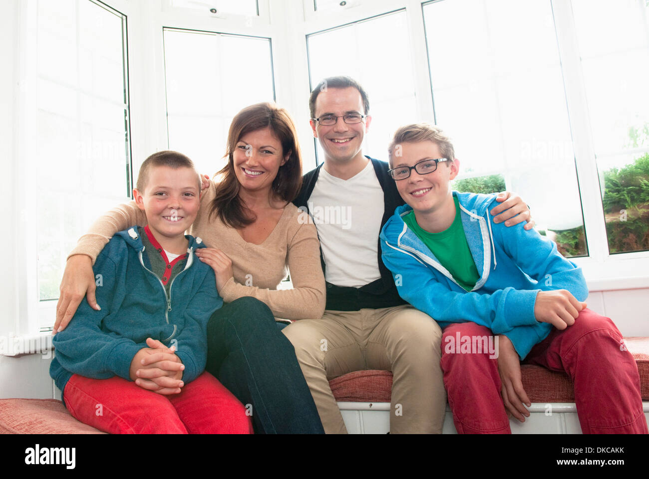 Family portrait in front of window Stock Photo - Alamy
