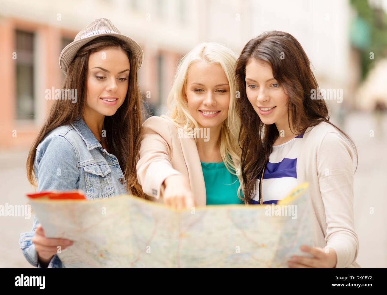 beautiful girls looking into tourist map in city Stock Photo - Alamy