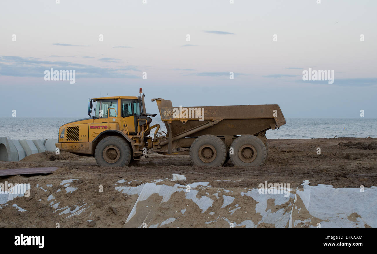A yellow large construction truck on the Beach at Bridlington East ...