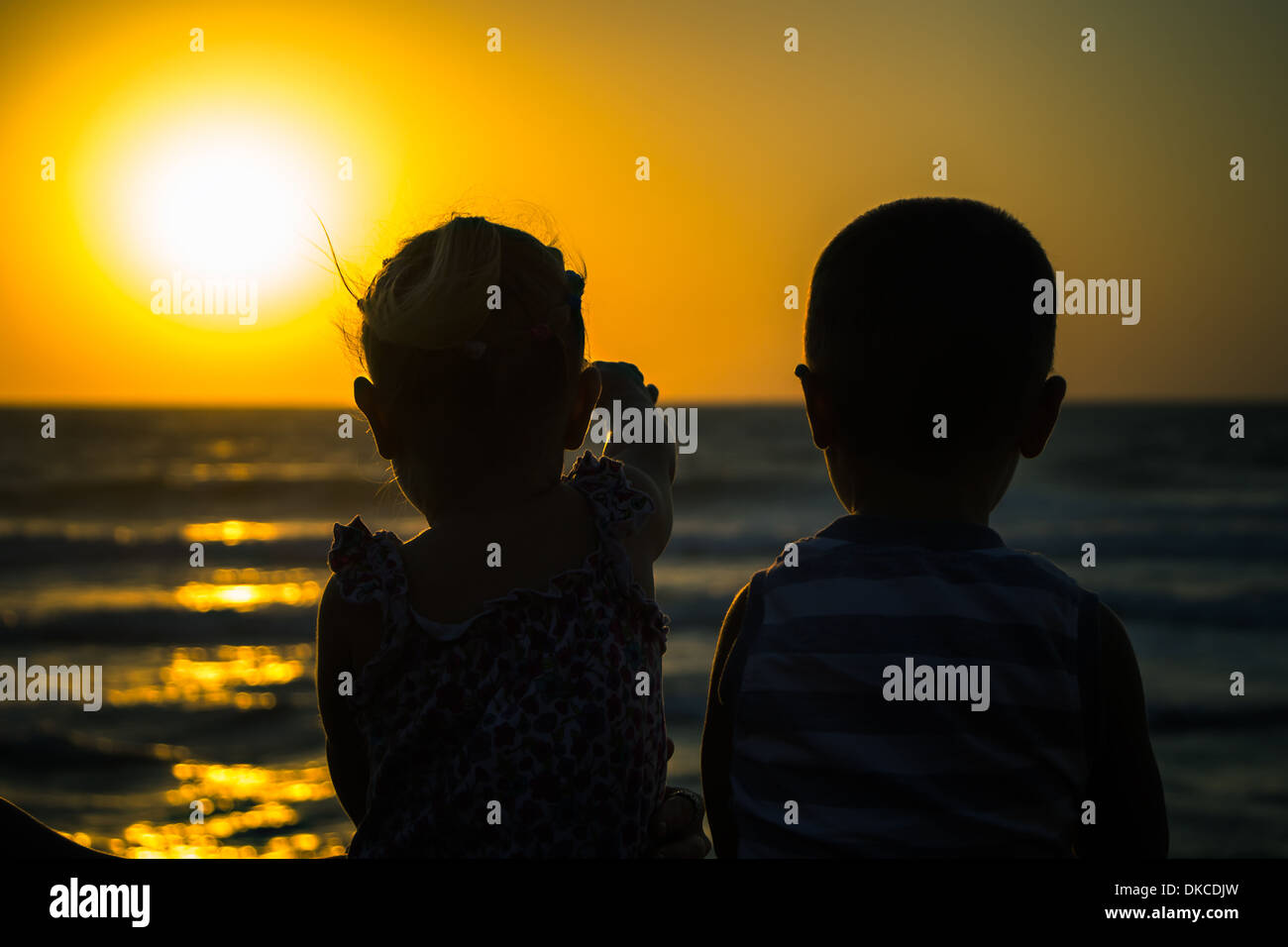 Silhouettes of happy children on a sunset by the sea Stock Photo - Alamy