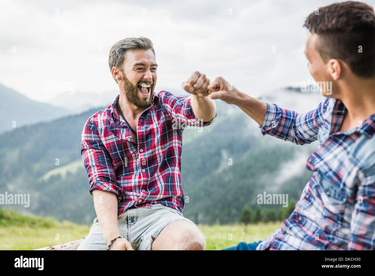 Two male friends sitting on fence hi-res stock photography and images ...