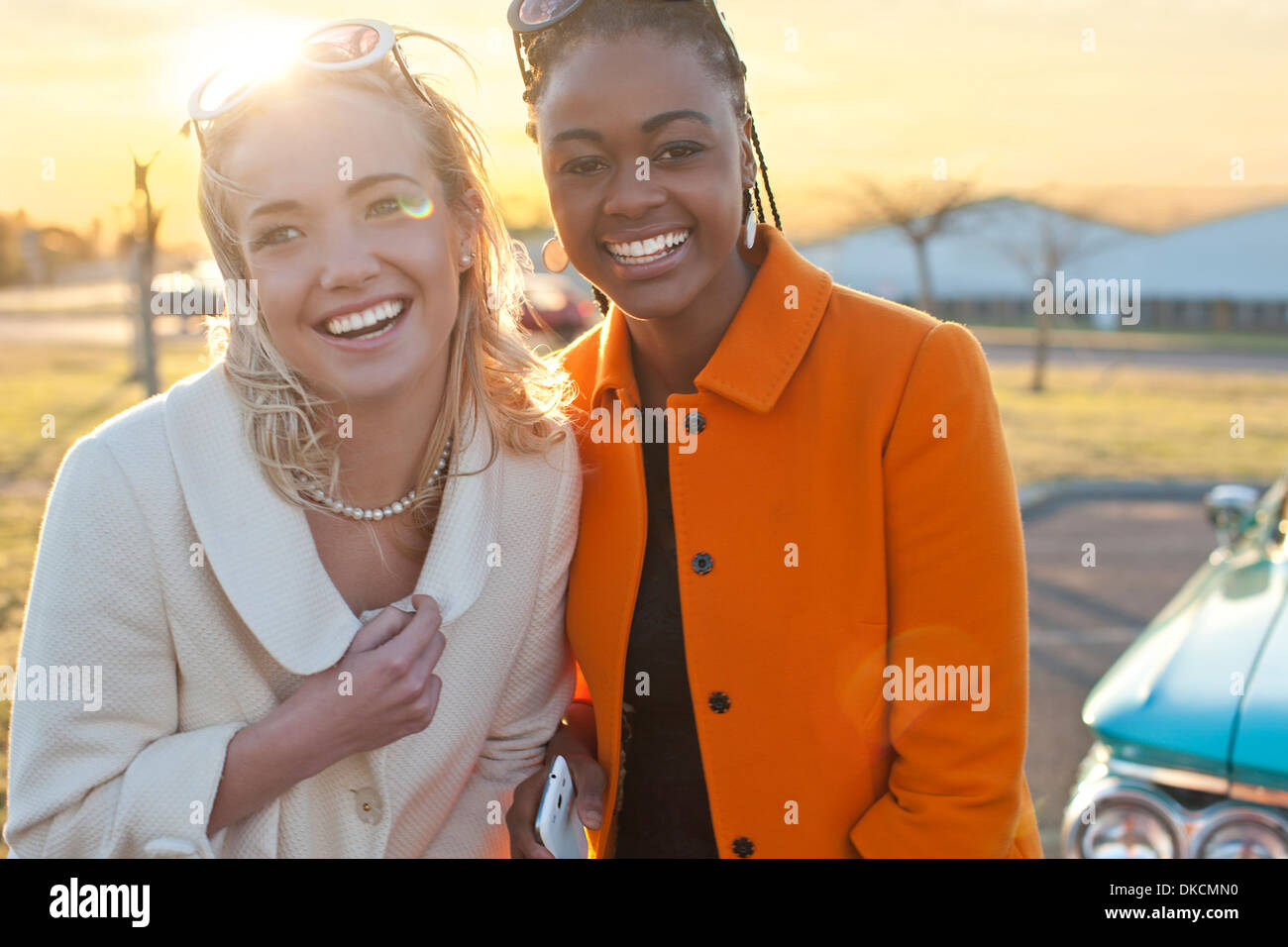 Women smiling for camera in front of vintage car Stock Photo - Alamy