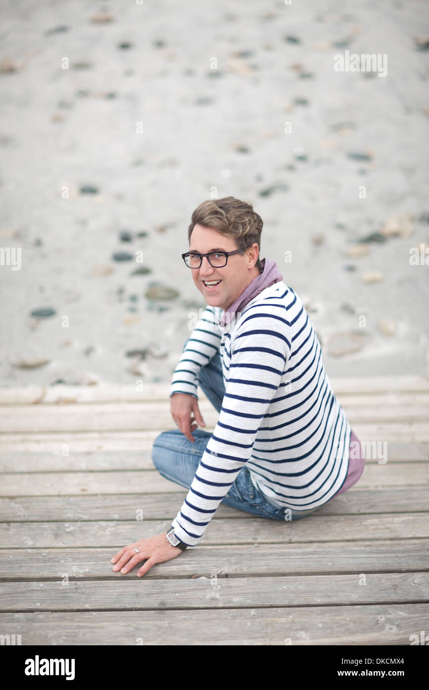 Man on beach turning around towards camera Stock Photo - Alamy