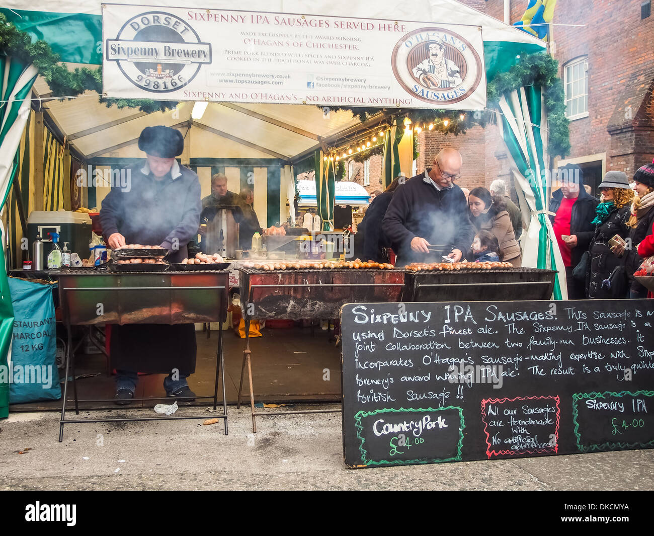 A sixpenny IPA Sausage stall with stall holders cooking sausages on a ...