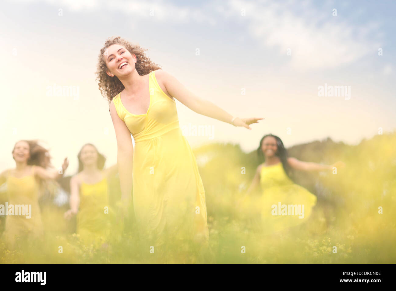 Girls in yellow dancing on meadow Stock Photo - Alamy