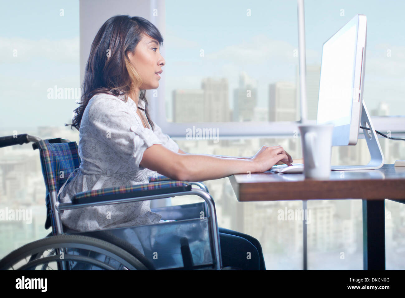 Woman in wheelchair using computer Stock Photo - Alamy