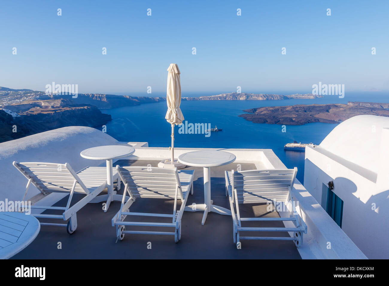 Tables and chairs ready for customers on a balcony at Fira, Santorini ...