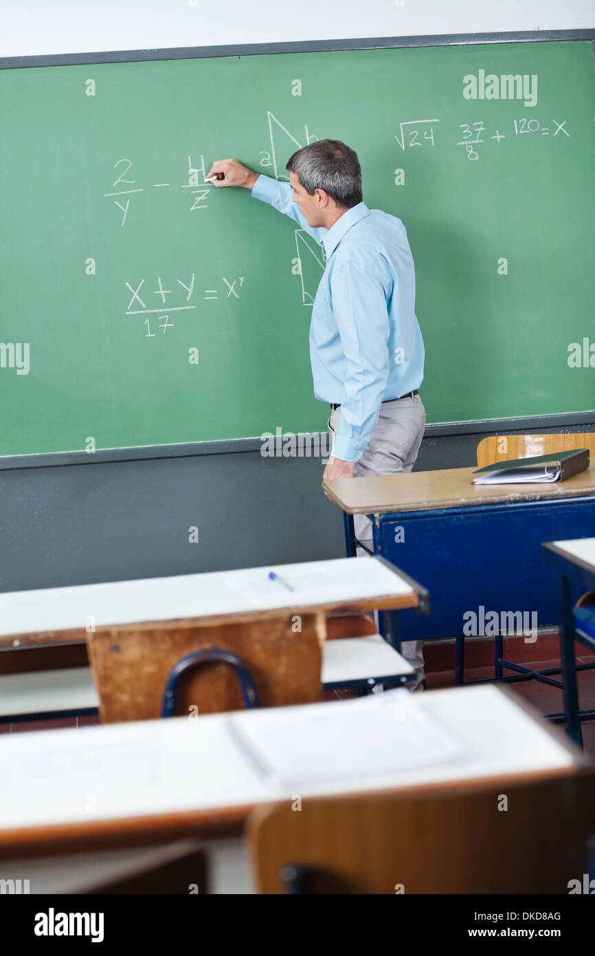 Male Teacher Writing On Greenboard Stock Photo - Alamy