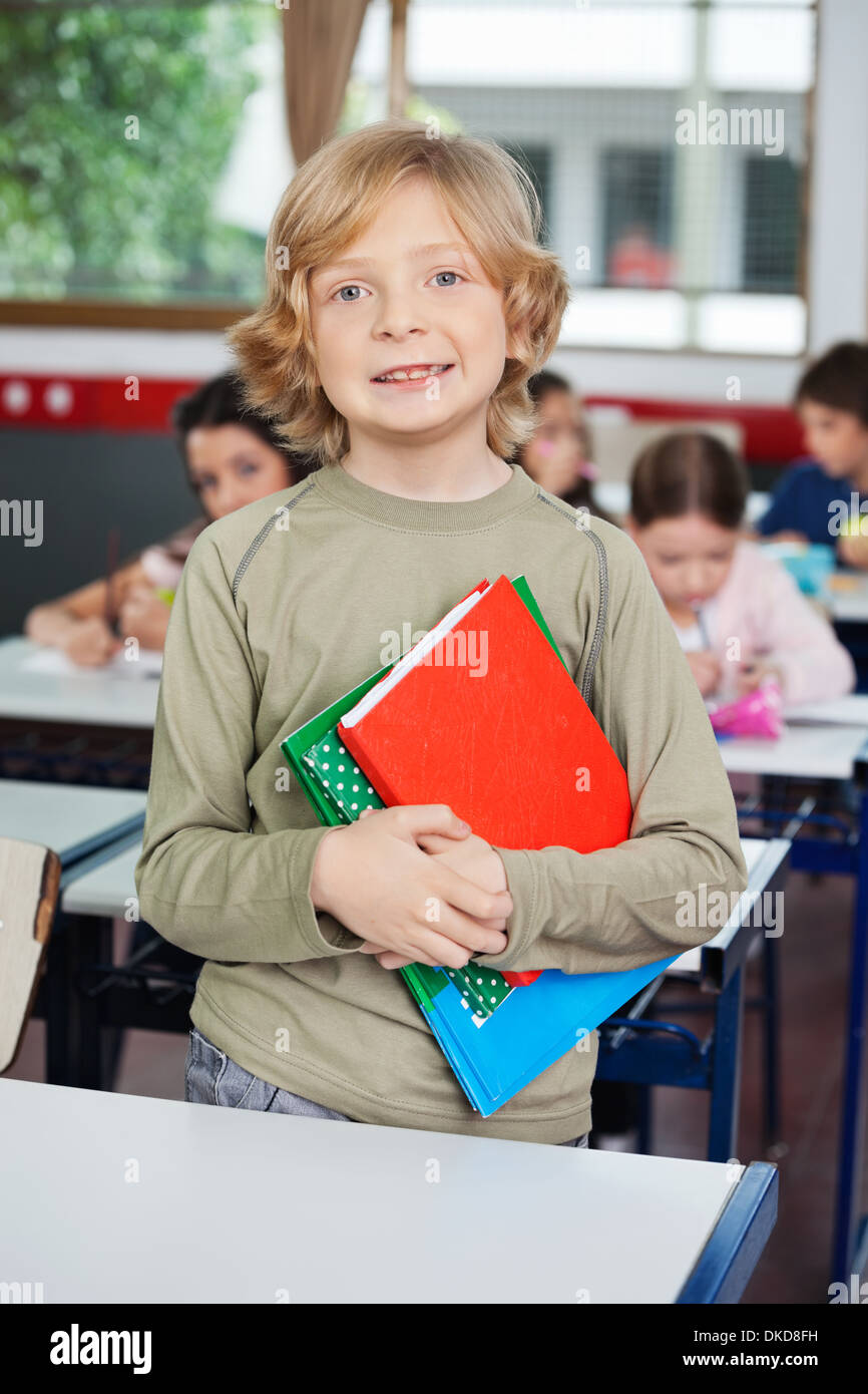 Schoolboy With Books Standing At Desk Stock Photo - Alamy