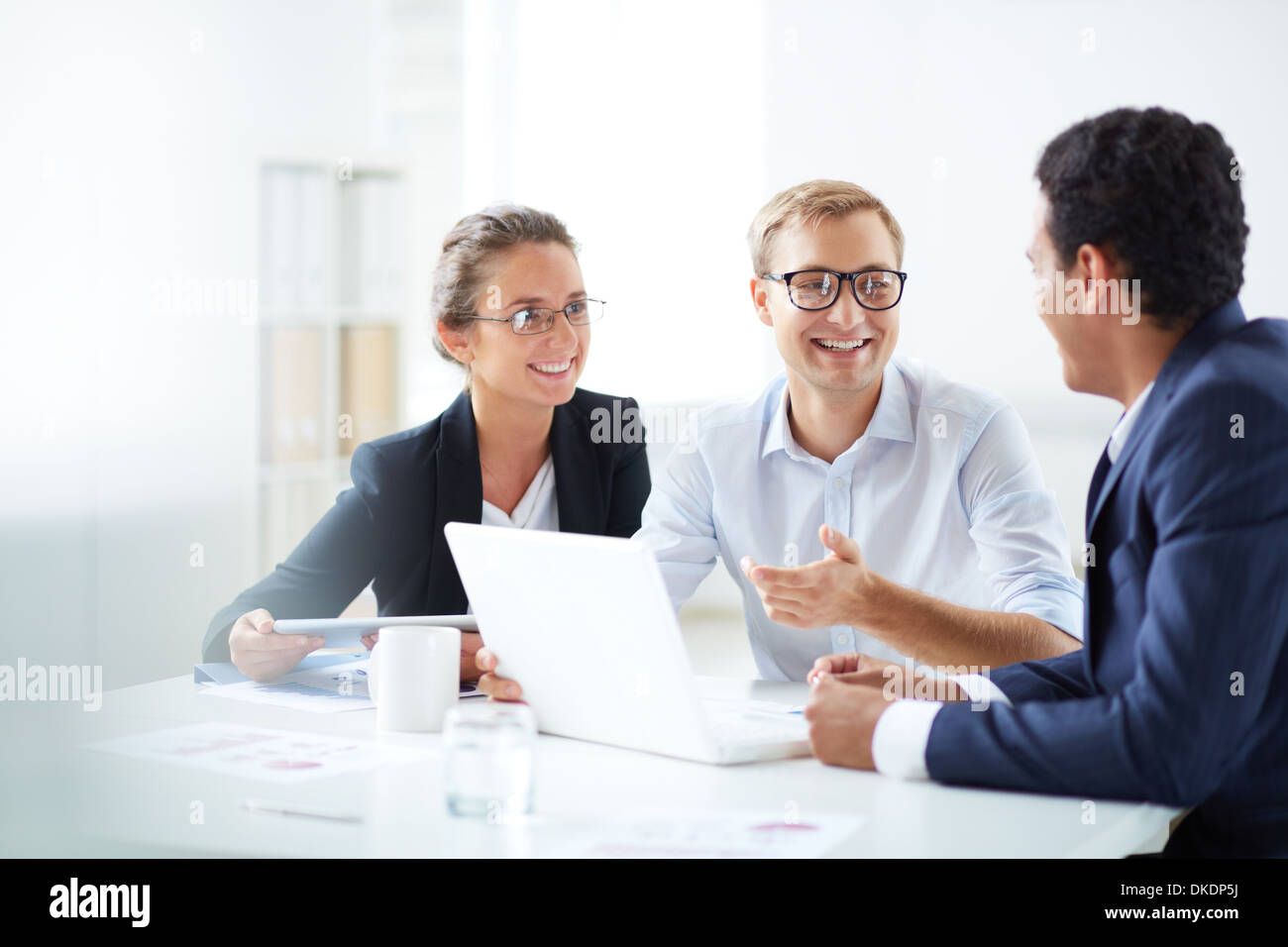 Portrait of smart business partners communicating at meeting Stock ...