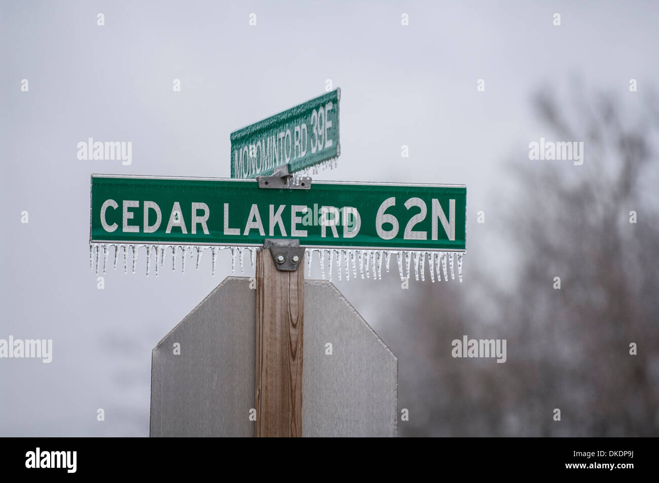 An intersection street signs with frozen drips hanging from the bottom ...