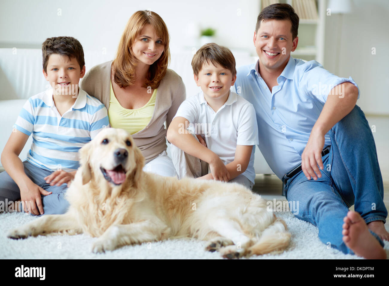 Portrait of happy family with their pet having rest at home Stock Photo ...