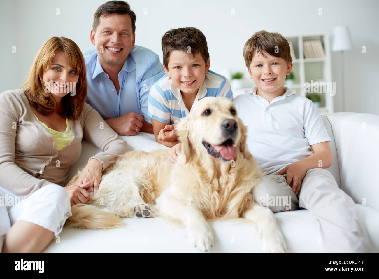 Portrait of happy family with their pet having rest at home Stock Photo ...