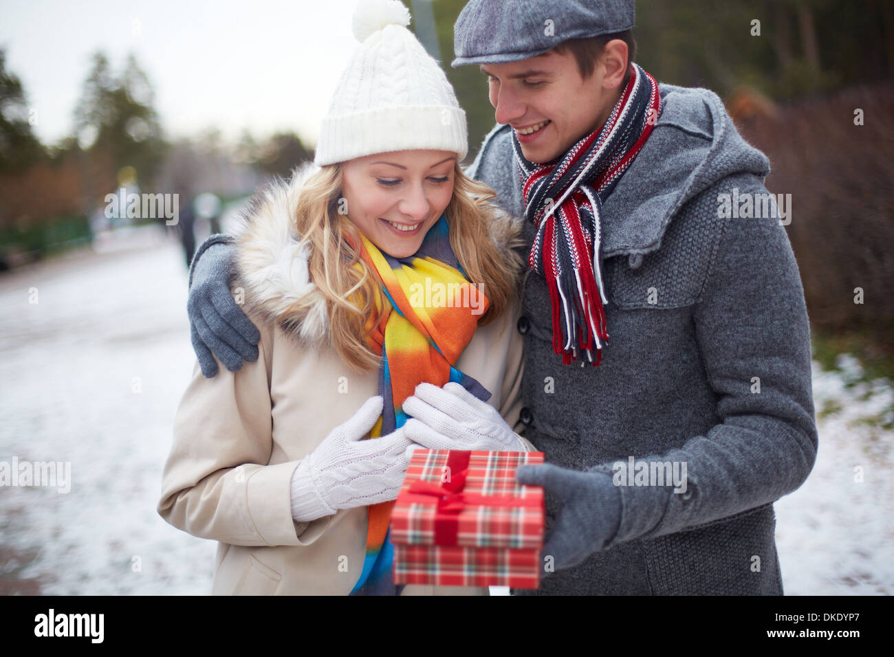 Image of affectionate guy giving his girlfriend Christmas present ...