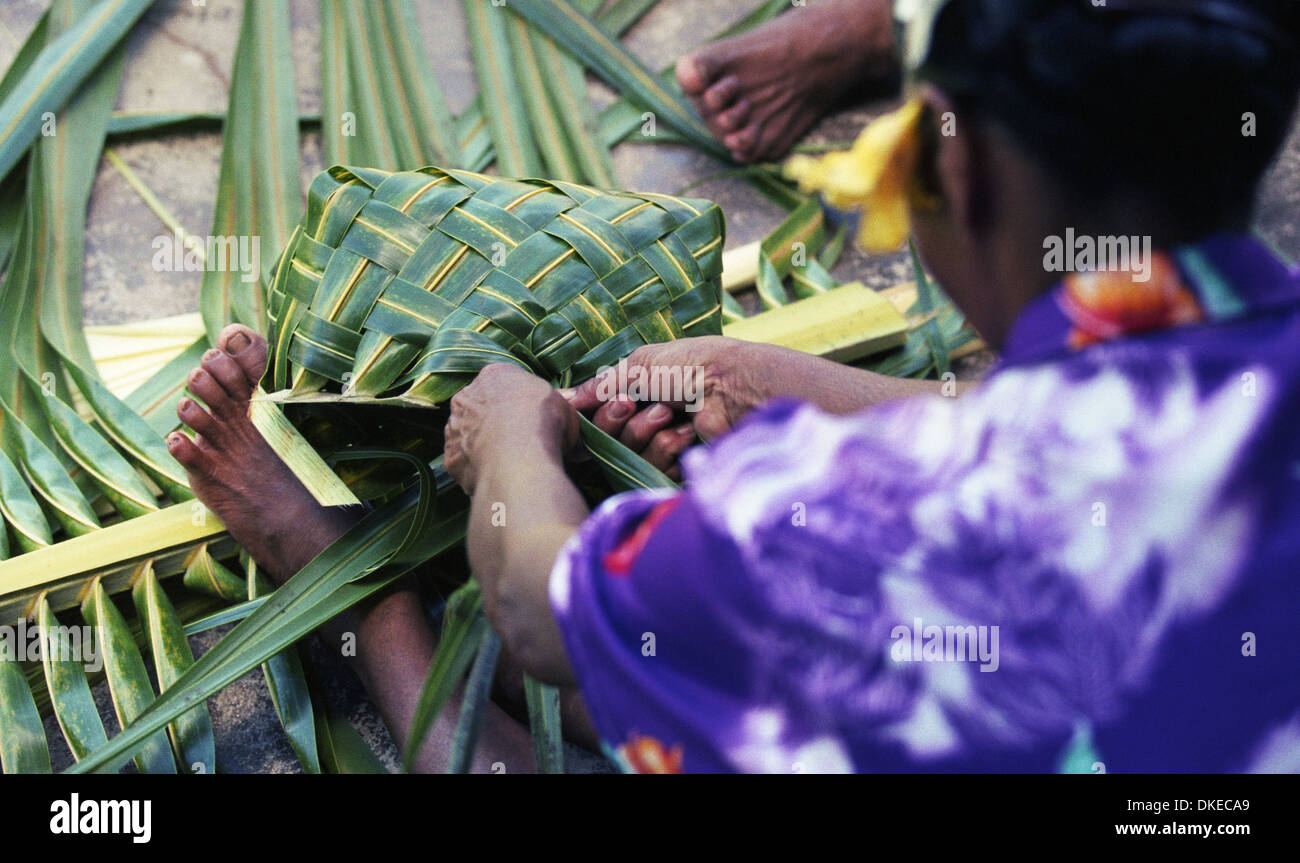 A Polynesian women weave baskets using materials from the coconut palm ...