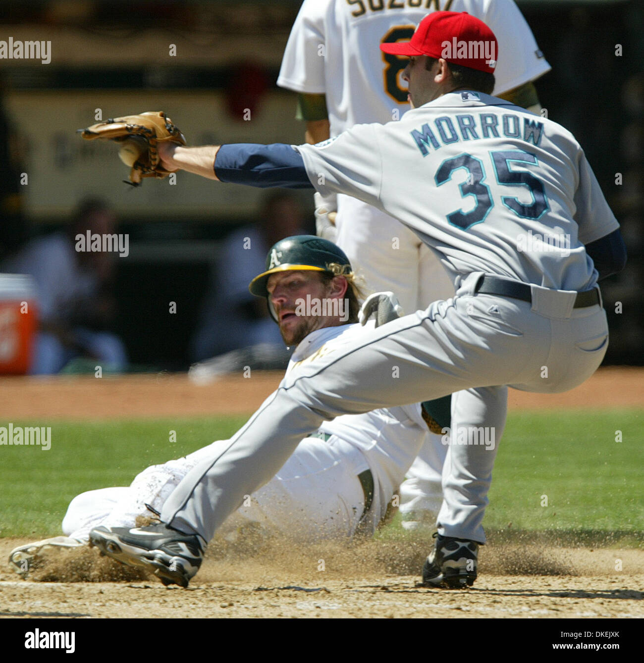 Athletics baserunner Travis Buck slides safely into home plate as ...