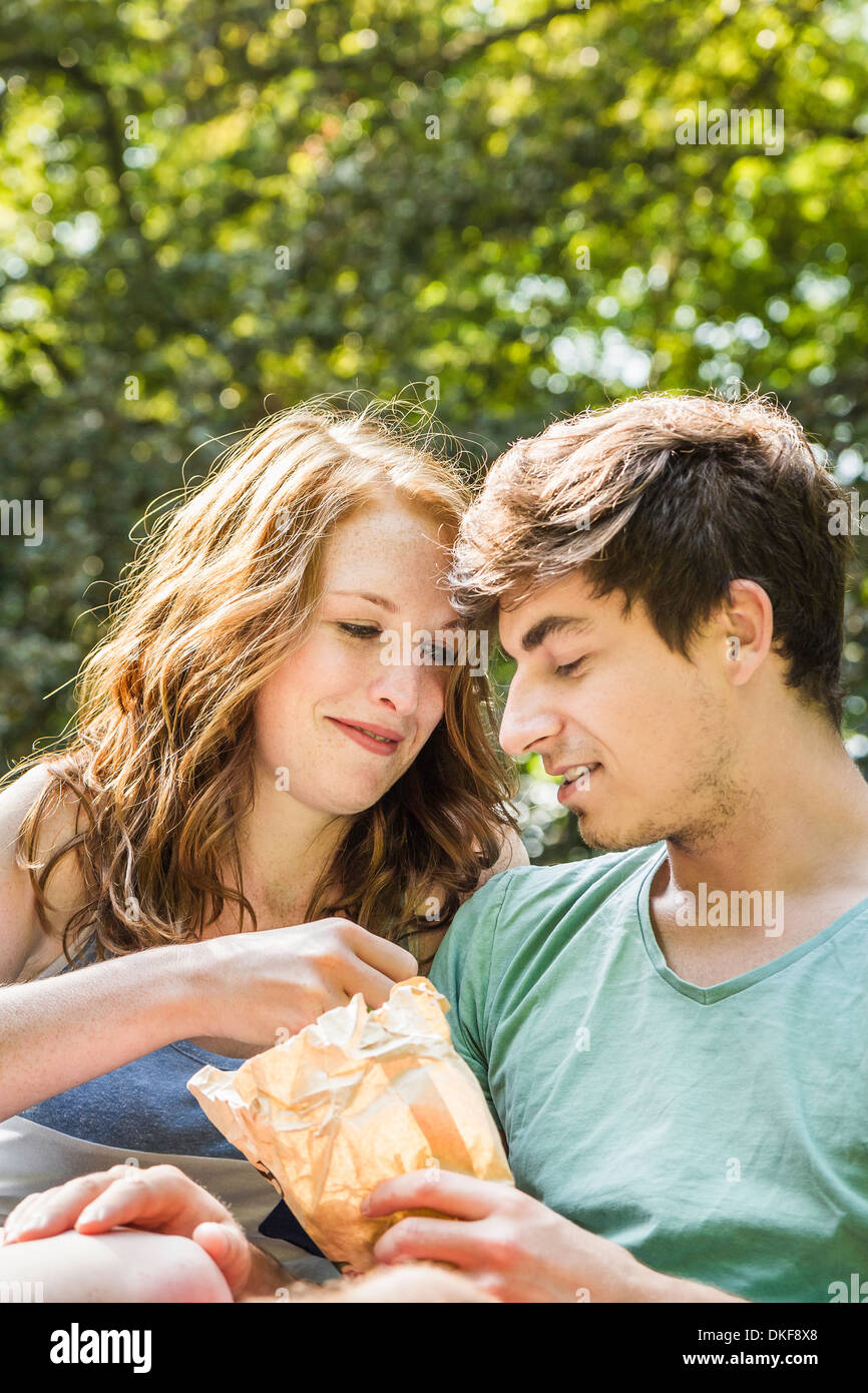 Young couple sharing bag of food Stock Photo - Alamy