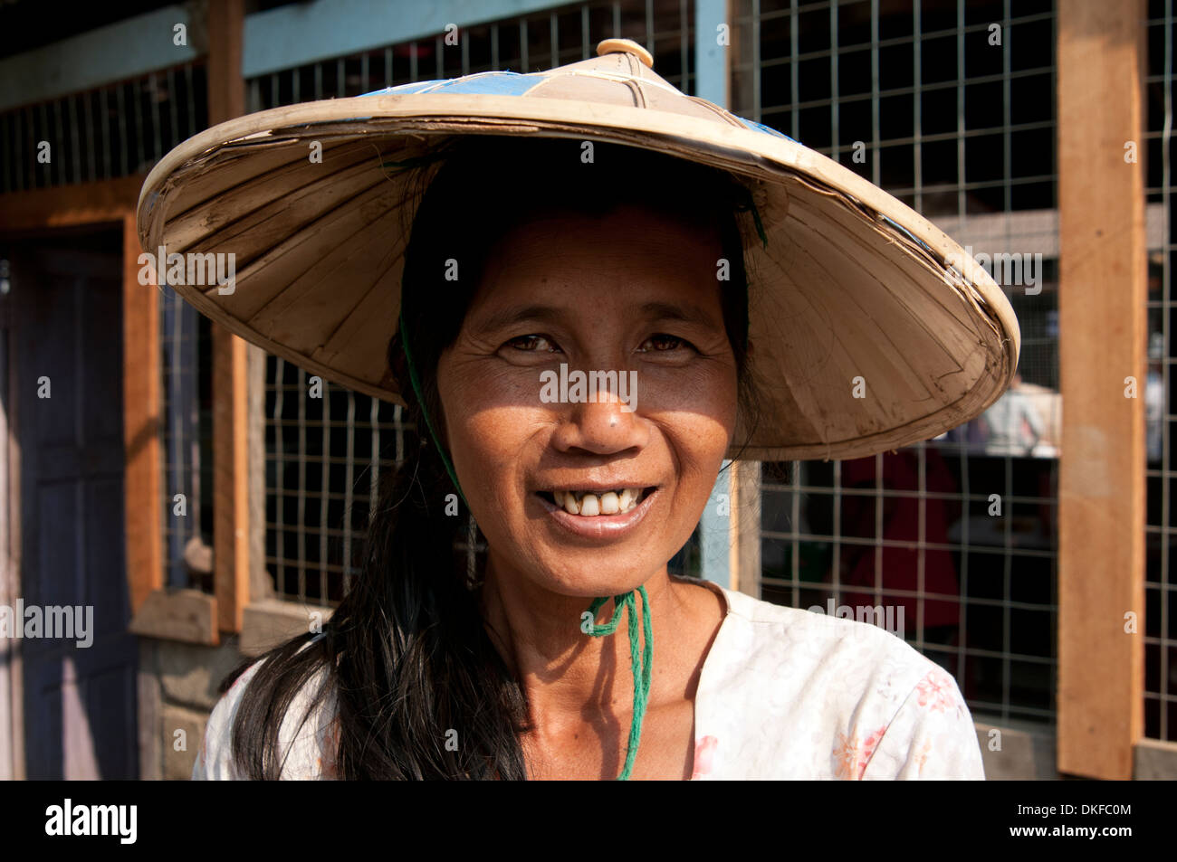 Woman wearing a bamboo conical Shan states hat smiling at the camera ...