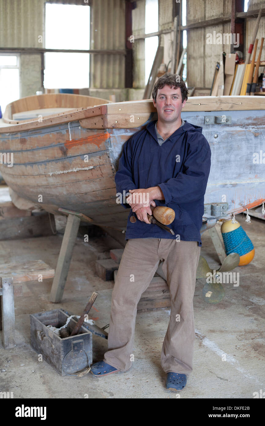 Portrait of mature man holding chisel in boat workshop Stock Photo - Alamy