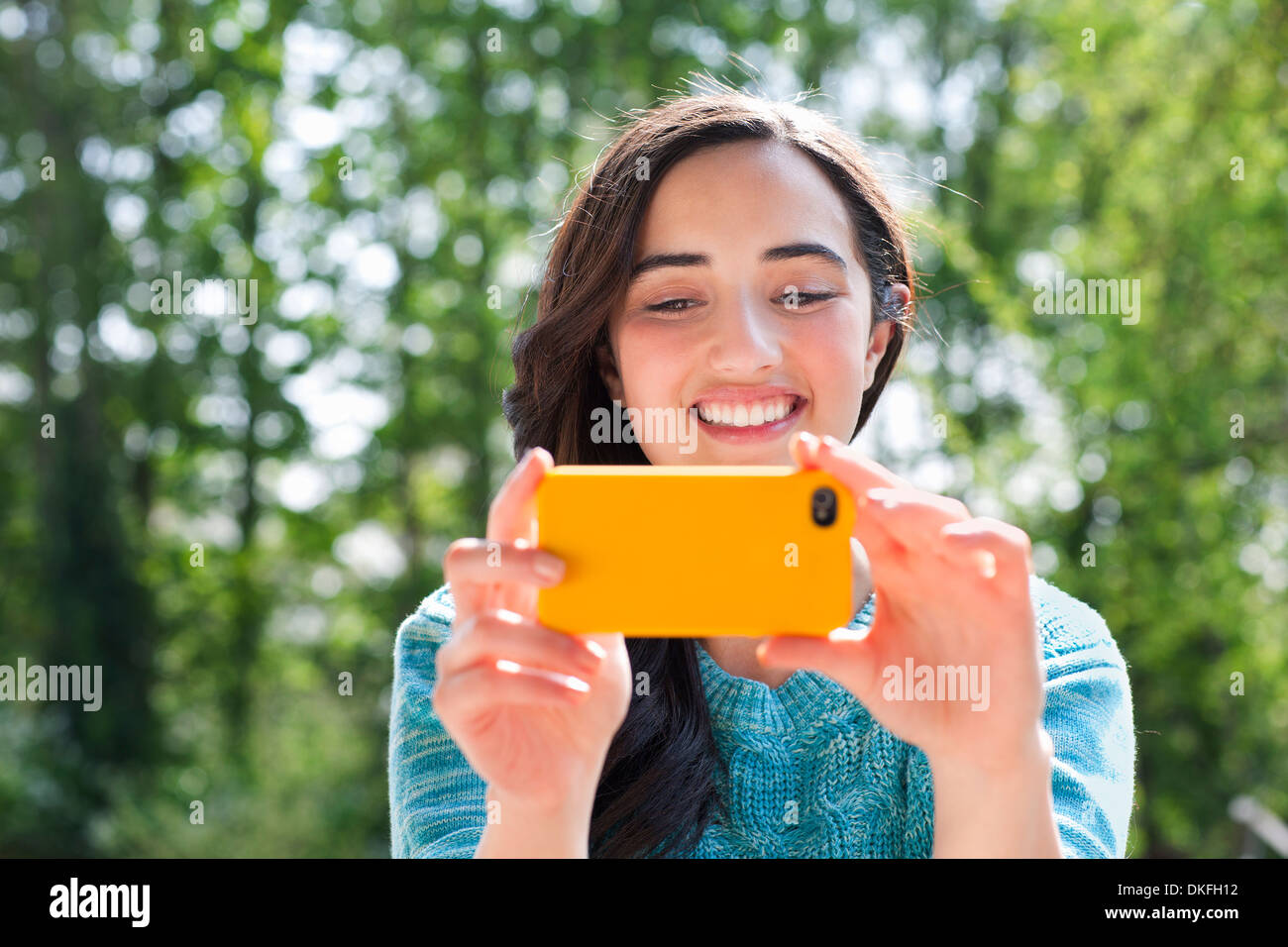 Portrait of young woman taking self portrait in garden Stock Photo - Alamy