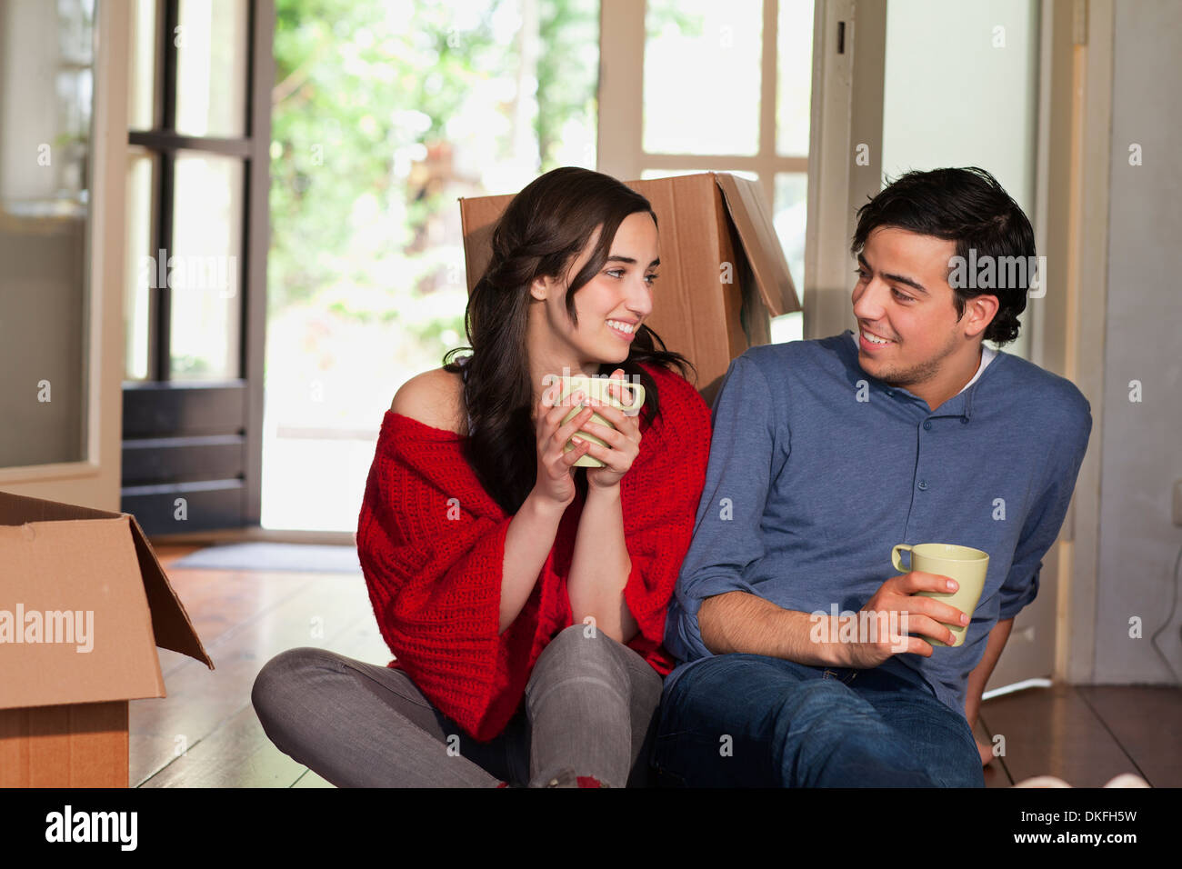 Young couple having coffee break whilst moving house Stock Photo - Alamy