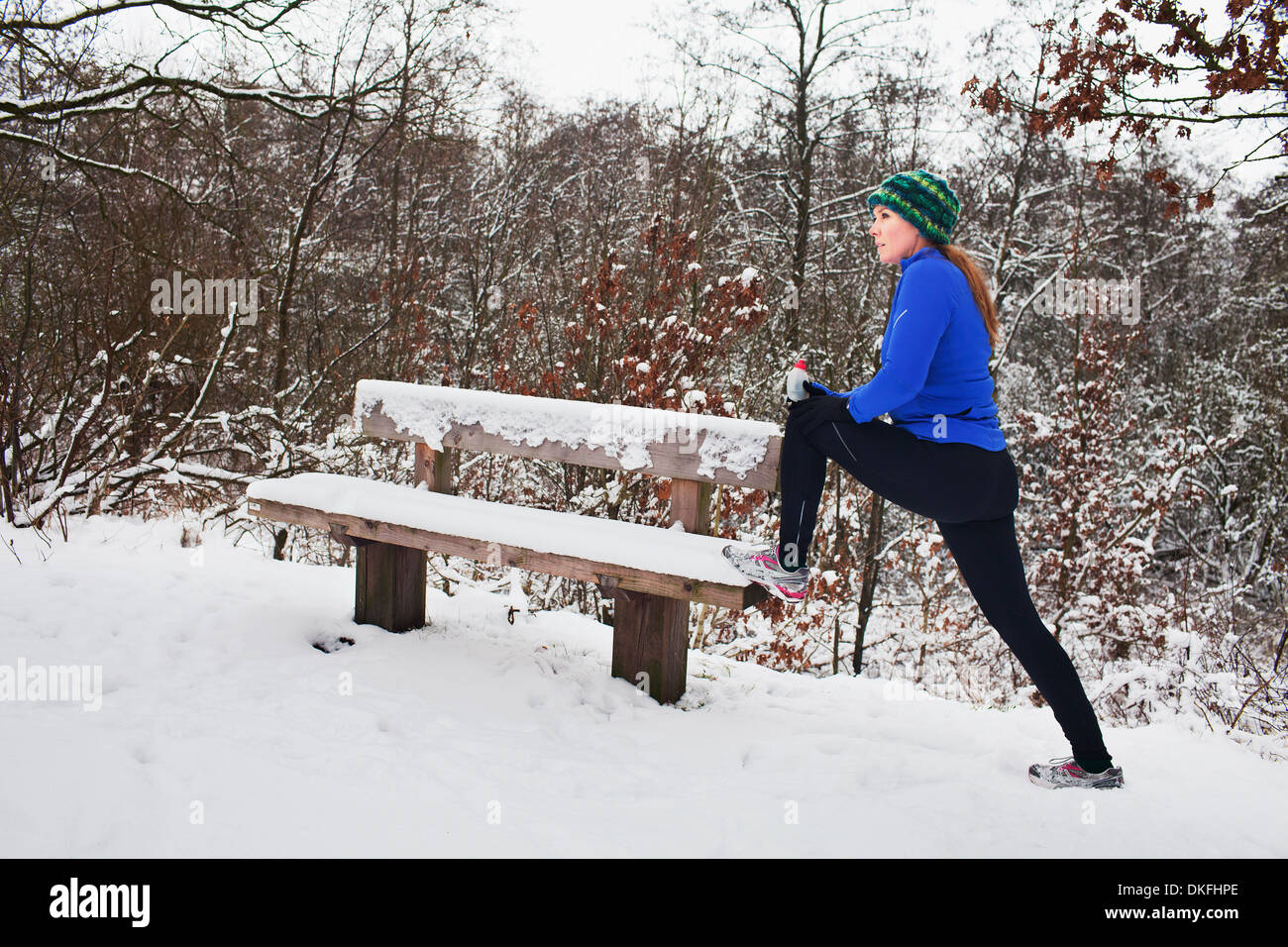Female runner doing stretch exercises in snow Stock Photo - Alamy