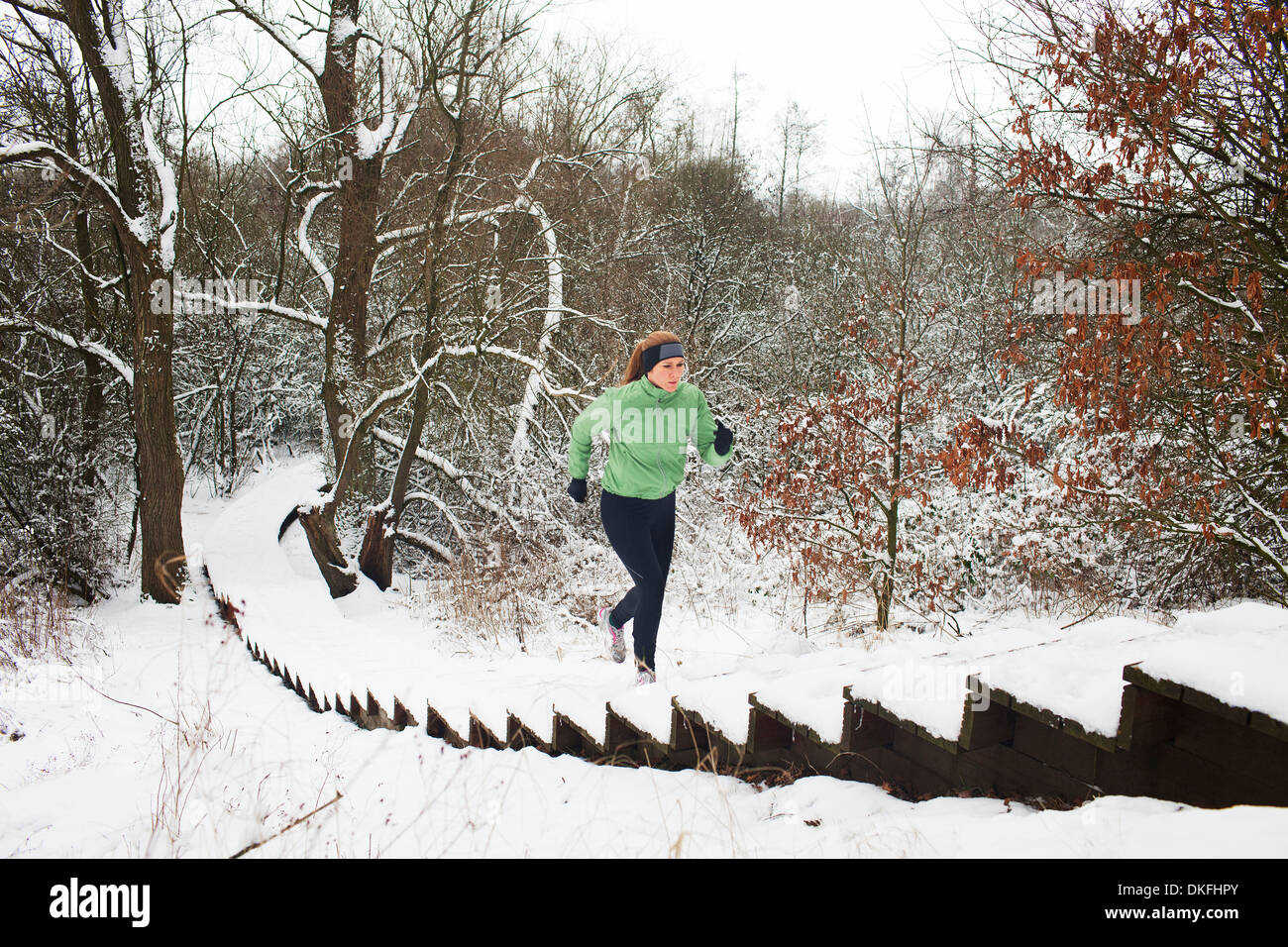 Female runner moving up snow covered staircase in winter Stock Photo ...
